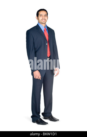 smiling businessman in formal wear standing with hand in pocket near ...