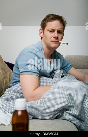 Sick man checking his temperature Stock Photo - Alamy