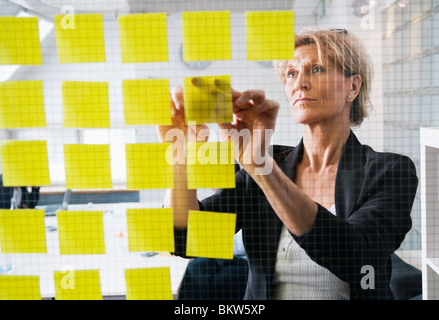 Businesswoman taking notes on a post-it; panoramic banner Stock Photo ...