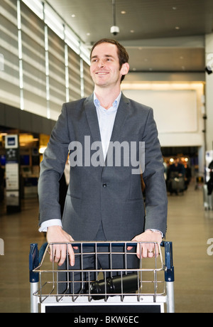 Man pushing baggage trolley Stock Photo - Alamy