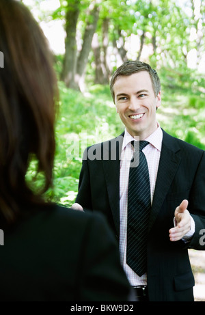 Businessman smiling and two businesswomen speaking Stock Photo - Alamy
