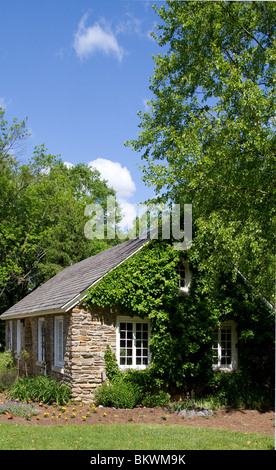 The gable end of a country cottage with ceder shakes stone chimney and ...