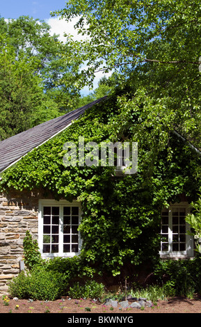 The gable end of a country cottage with ceder shakes stone chimney and ...