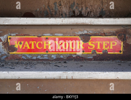 Watch your step sign on old train steps Stock Photo - Alamy