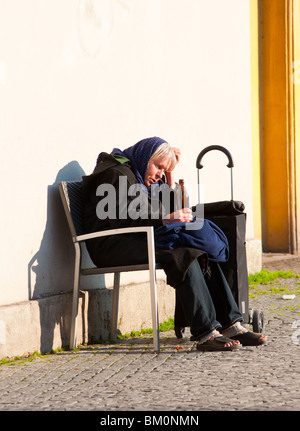 DRUNK HOMELESS WOMAN IN DESPAIR IN THE STREETS OF ROME WITH A BOTTLE OF ...