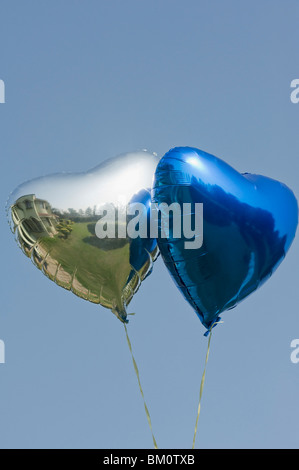 Heart-shaped balloons flying in the sky attached to a string Stock ...