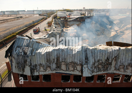 Large factory and warehouse collapsed and smoldering following major ...
