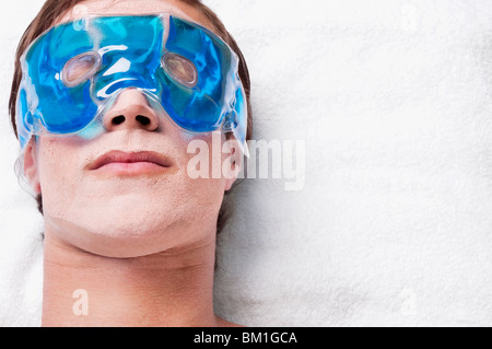 Young hispanic man wearing beauty face mask and bath robe in hurry ...