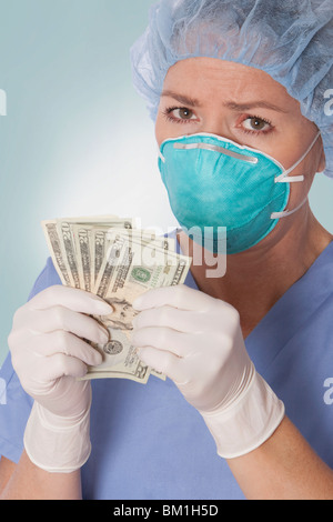 Female surgeon doctor holding money Stock Photo - Alamy