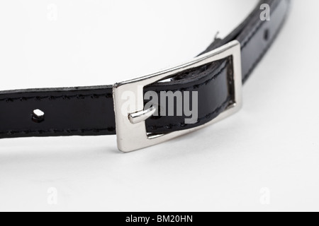Black leather belt with a metal buckle on a dark background close-up ...
