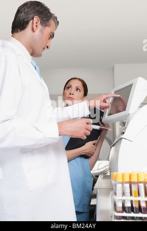 Close up of lab technician taking liquid samples with pipette while ...