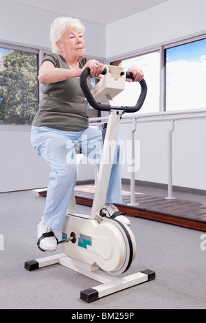 Woman exercising on an exercise bike Stock Photo - Alamy