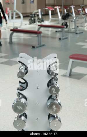 Dumbbells on a rack and on the floor at the gym Stock Photo - Alamy