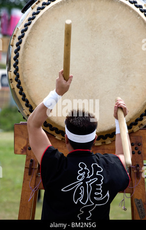 Drummer performing on a Japanese taiko (ō-daiko) drum using bachi drum ...