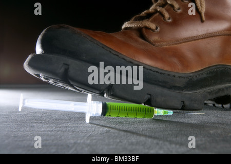 Boot treading a green liquid syringe, leaving drug addiction metaphor ...