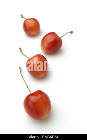 four ripe red cherries in an unusual pose on a dark background with ...