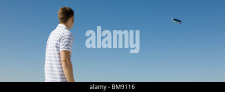 Man looking at blimp in sky Stock Photo - Alamy