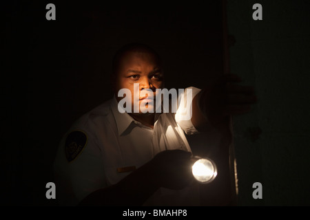 Security Guard With Flashlight Standing In Corridor Stock Photo - Alamy