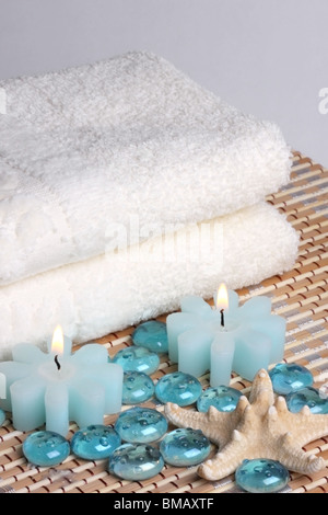 Spa stones with towel, candles, bamboo and pink orchid on wooden ...