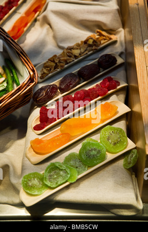 Multi-coloured dried fruits in a wattled basket separately on a white ...