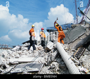 Civil Defence workers search for survivors in a huge pile of rubble and ...