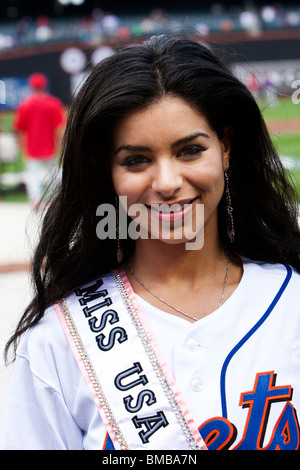 Miss USA, Rima Fakih, wearing jersey, holding pink bat and blue cap at ...