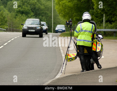 Traffic police officer with mobile speed camera on tripod checking ...