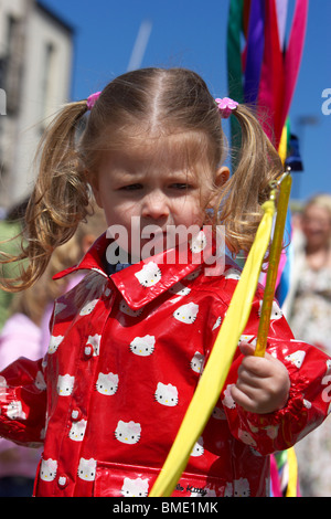 young girl dancing with ribbon around a mini maypole on may day in ...