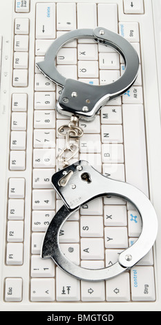 A computer keyboard and handcuffs. Cybercrime. Austria Stock Photo - Alamy