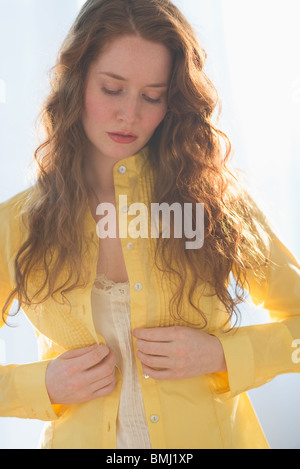 Woman buttoning her shirt Stock Photo - Alamy