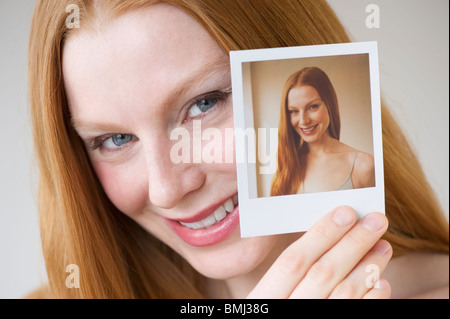 Pretty woman taking a photograph of herself in a mirror of showcase ...