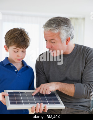 Man showing his son solar panels during sunny day. Father presentng to ...