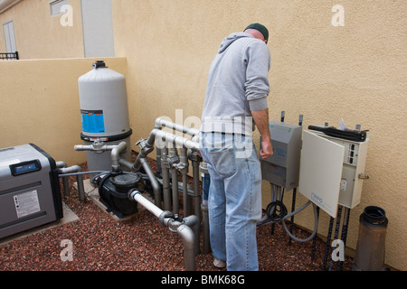 Man turning valve of a swimming pool system Stock Photo - Alamy