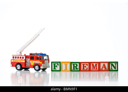Colorful children's blocks spelling FIREMAN with a toy fire truck Stock ...