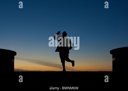 Silhouette of Eric Morecambe statue (of Morecambe and Wise) on the sea ...