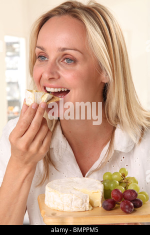 Woman eating camembert Stock Photo - Alamy