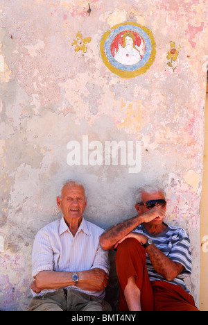 Two elderly Maltese men sitting down at the harbour in Marsaxlokk ...