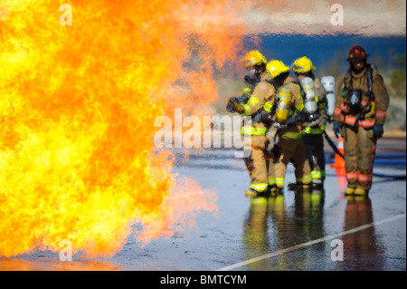 Heat waves partially obscure a team of firefighters preparing to attack ...