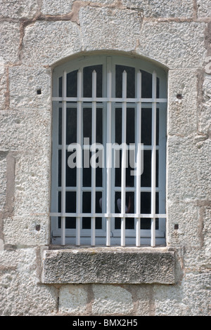 barred bars arch window stone wall peephole small Stock Photo - Alamy