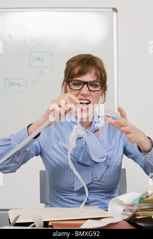 A close-up hand with fingers stuck in a toy black doll's boots steps on ...