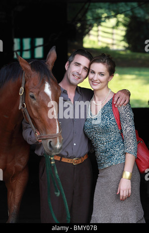 romantic couple with horse in barn Stock Photo - Alamy