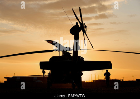 A helicopter crew member stands beside his UH-1N Iroquois helicopter as ...