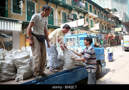 People unload sacks from a lorry in the town of Man in northern rebel ...
