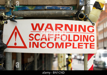 Warning sign at scaffolding warning that it is incomplete and do not ...