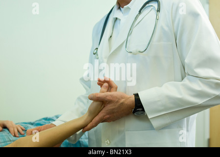 Doctor examining patient's arm Stock Photo - Alamy