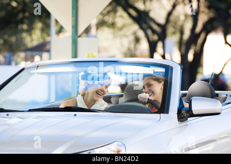 Happy woman driving car with her friend in passenger seat Stock Photo ...