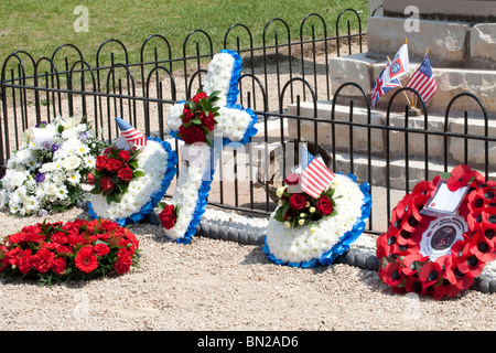 Poppies, reefs and flowers laid in front of a war memorial in tribute ...