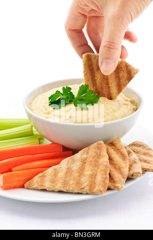 Hummus served with pita bread and veggies. Spicy sauce can be added to ...