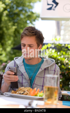 Low angle view of man using phone against Brooklyn Bridge Stock Photo ...