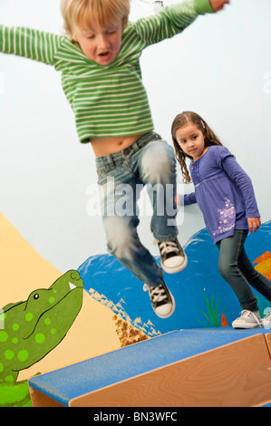 Children jumping over boxes, low angle view Stock Photo - Alamy